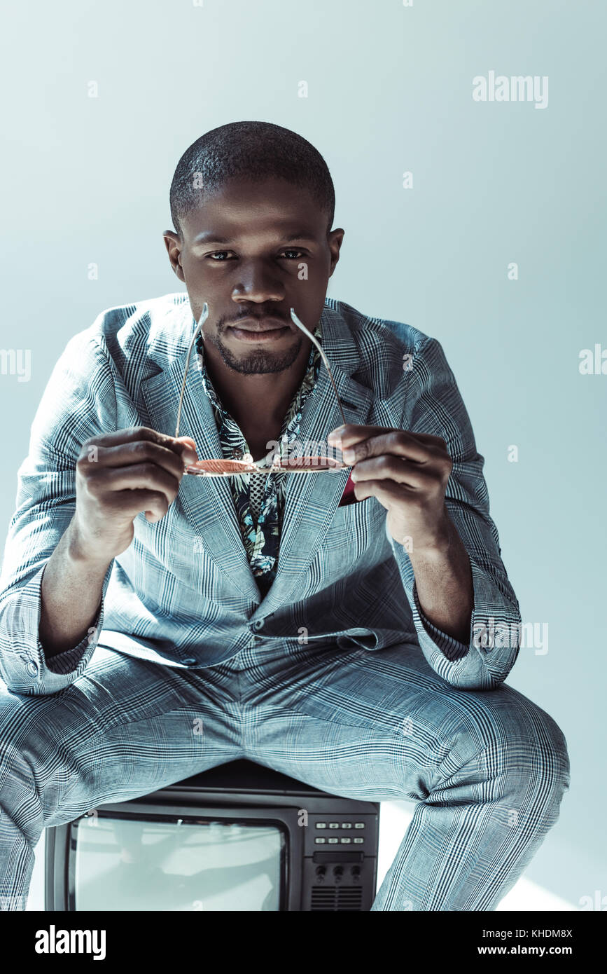 Stylish man sitting on retro tv Stock Photo - Alamy