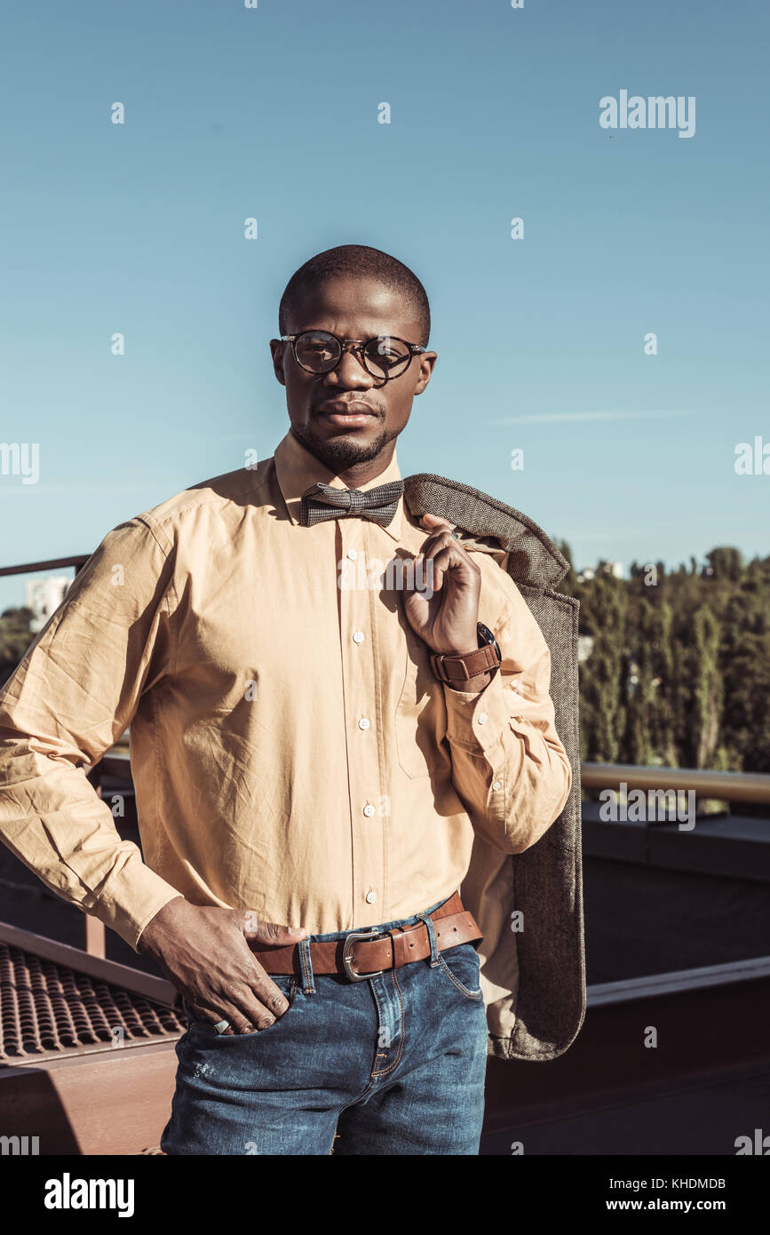 Stylish man holding jacket on shoulder Stock Photo - Alamy
