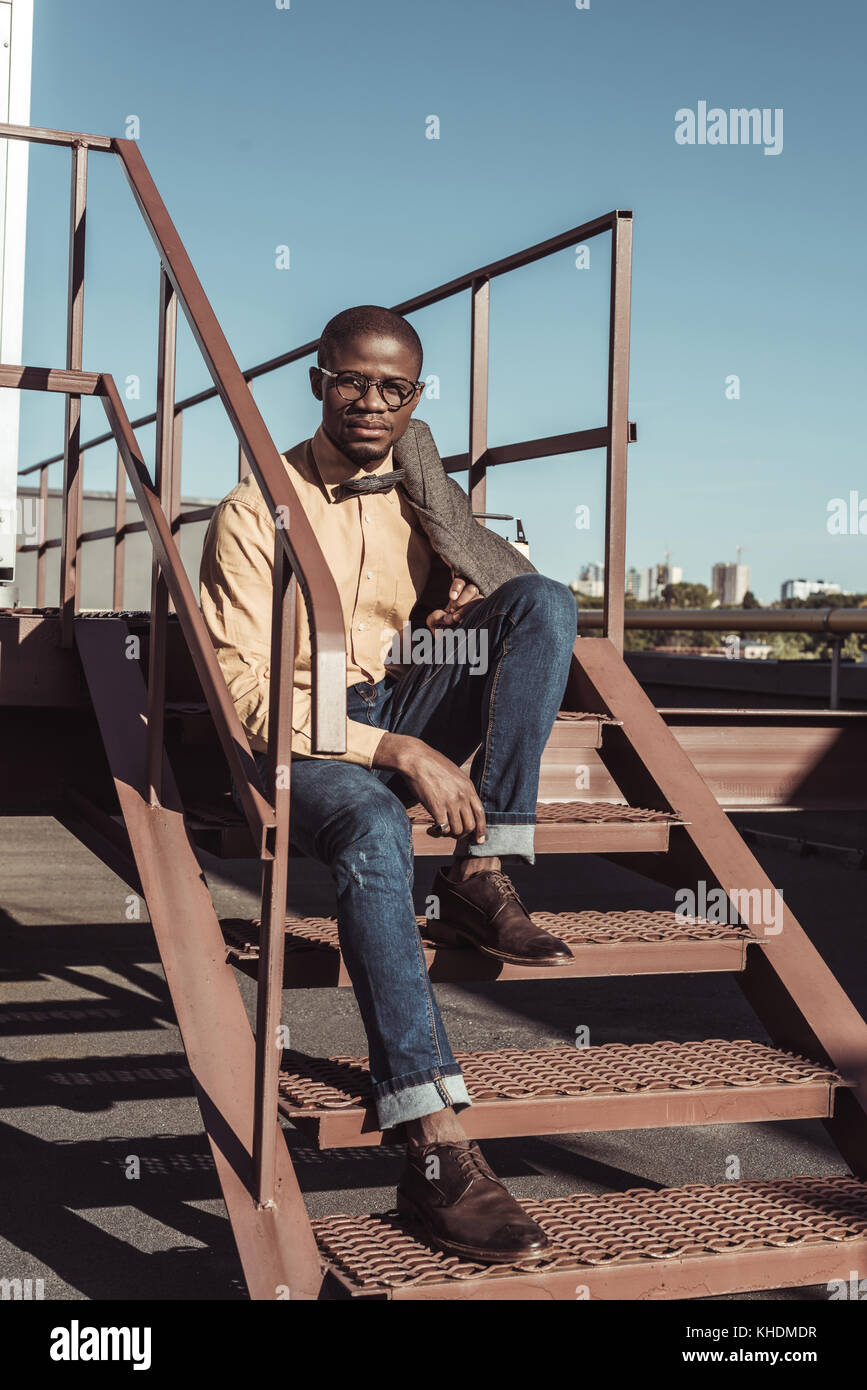 Stylish man sitting on stairs Stock Photo - Alamy