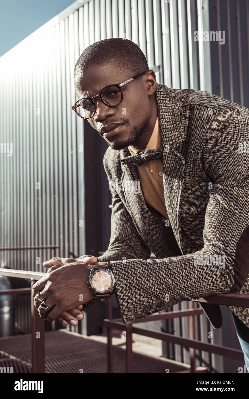 Stylish african american man leaning on guardrails Stock Photo - Alamy