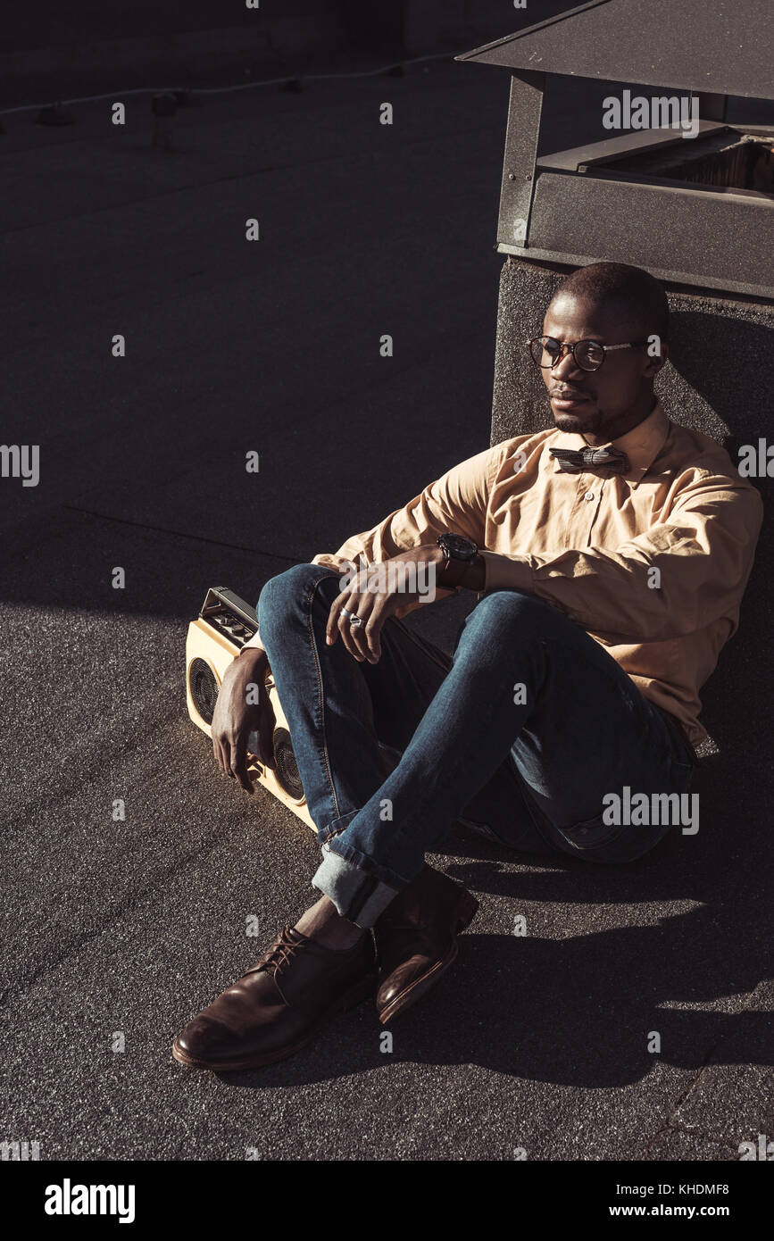 Stylish african american man sitting on rooftop Stock Photo - Alamy