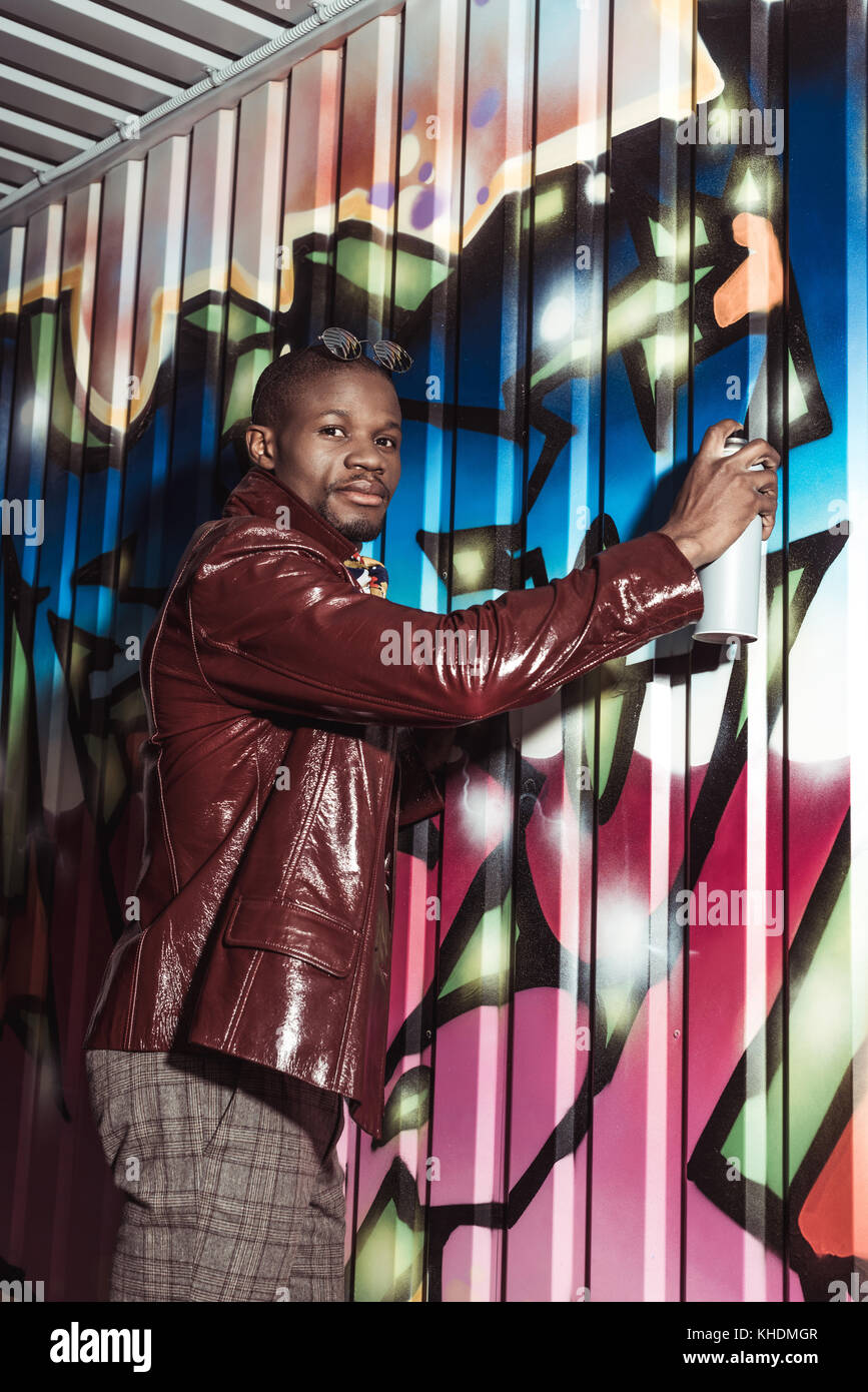 Fashionable man painting graffiti Stock Photo - Alamy