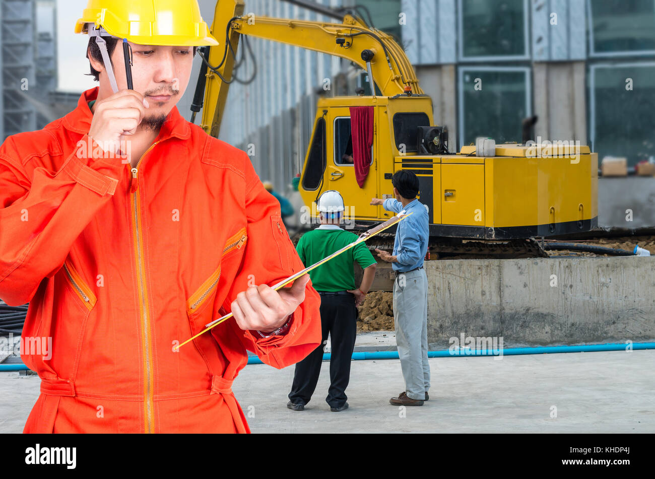 Asian engineers thinking and holding the note pad on construction site ...