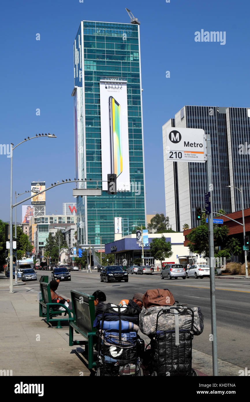 Homeless people sitting on a bus stop bench and view of Sunset Vine ...