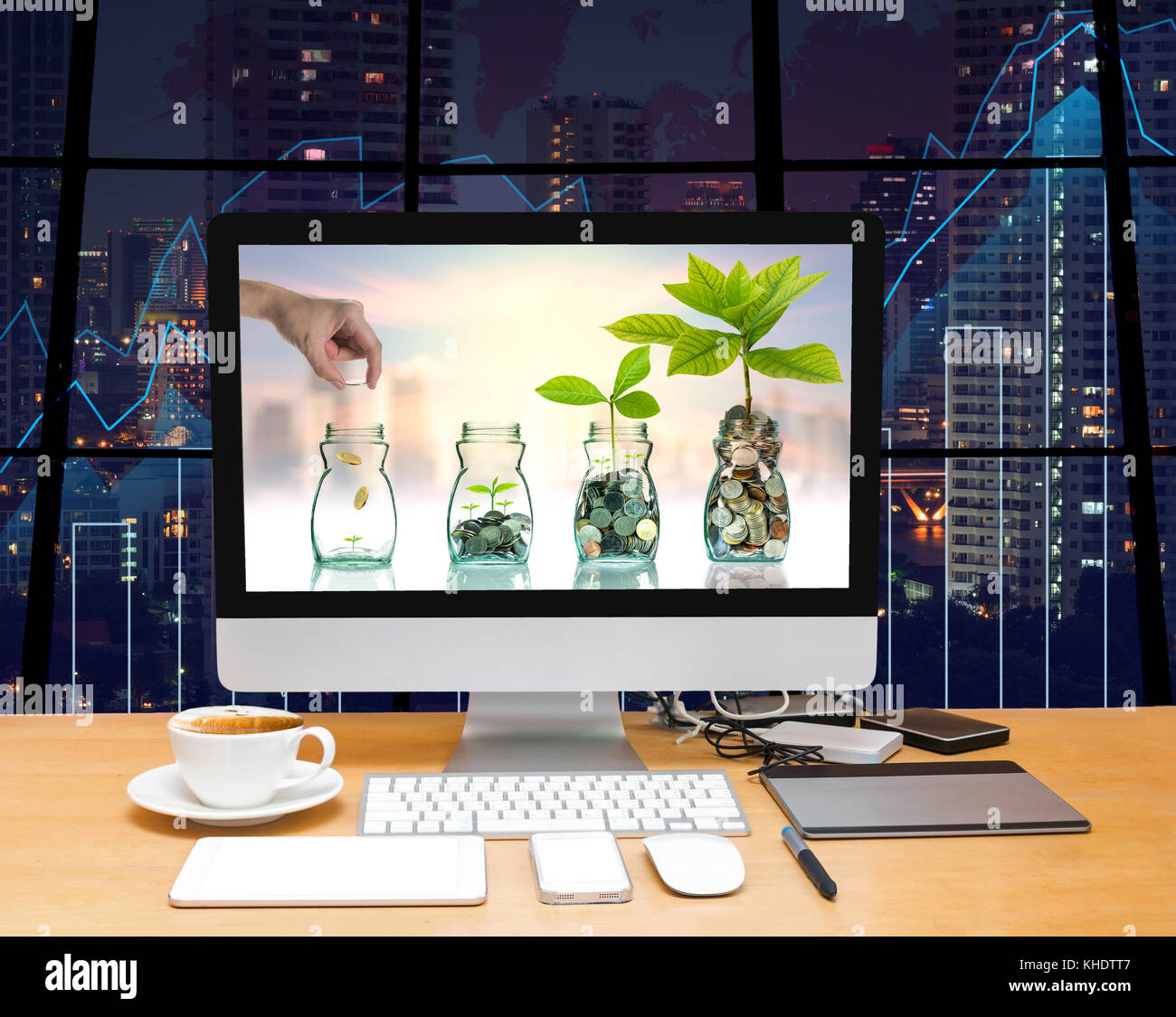 Workspace with computer desktop with Hand putting mix coins and seed in ...