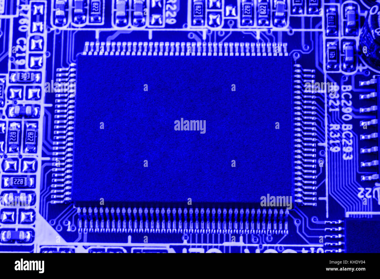 Integrated semiconductor microchip on blue circuit board representative ...