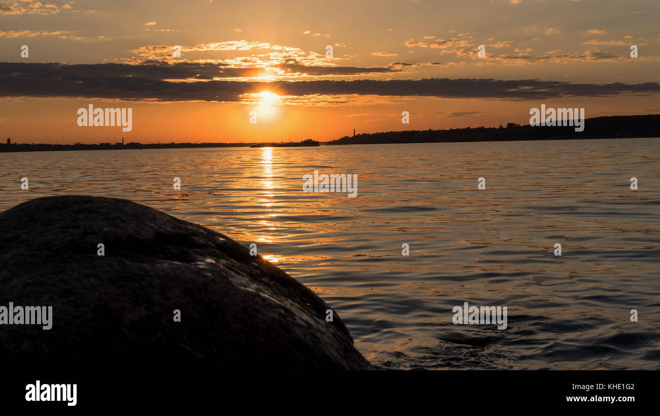 Beautiful red and orange sunset over the river with the sun and clouds ...