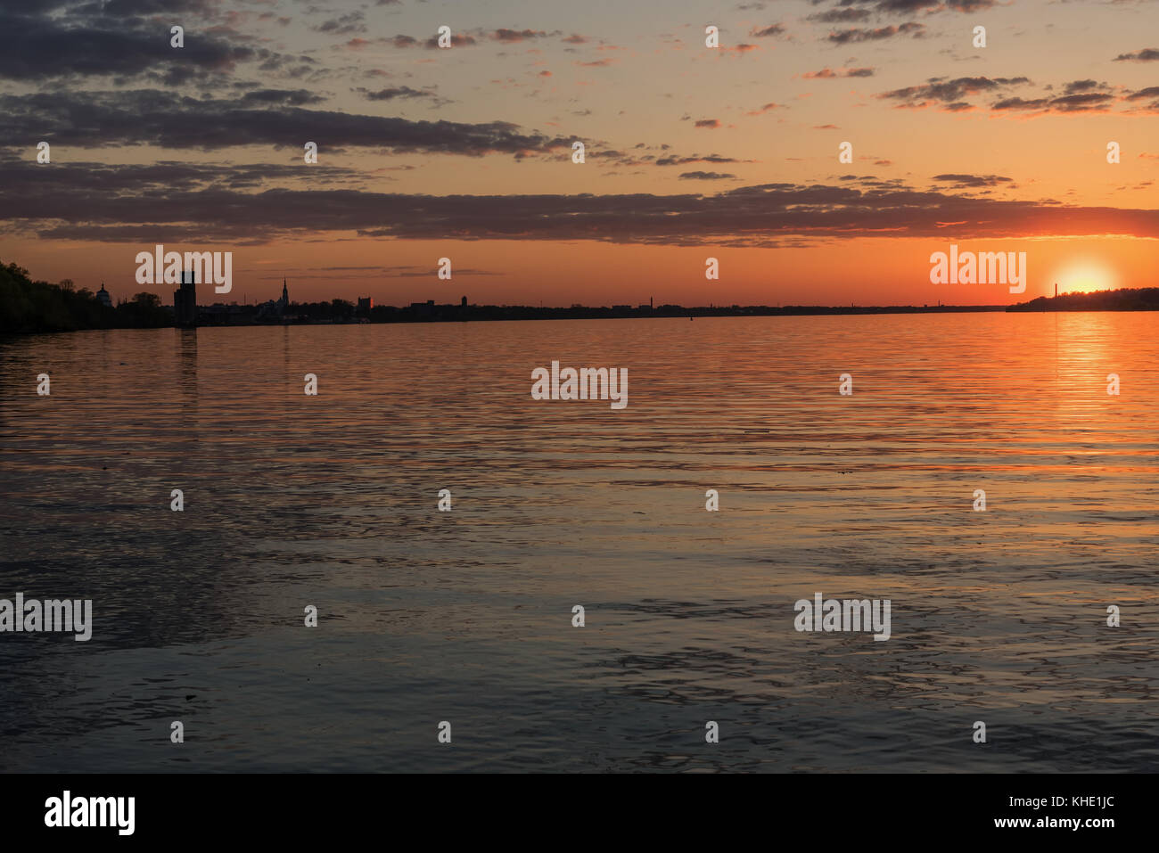 Beautiful red and orange sunset over the river with the sun and clouds ...
