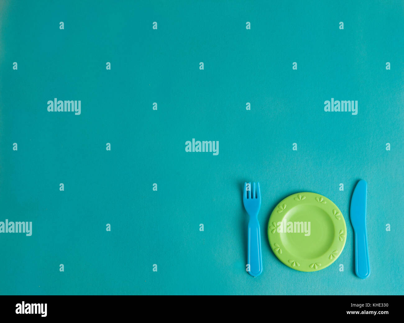 cutlery and empty plate on turquoise background Stock Photo - Alamy