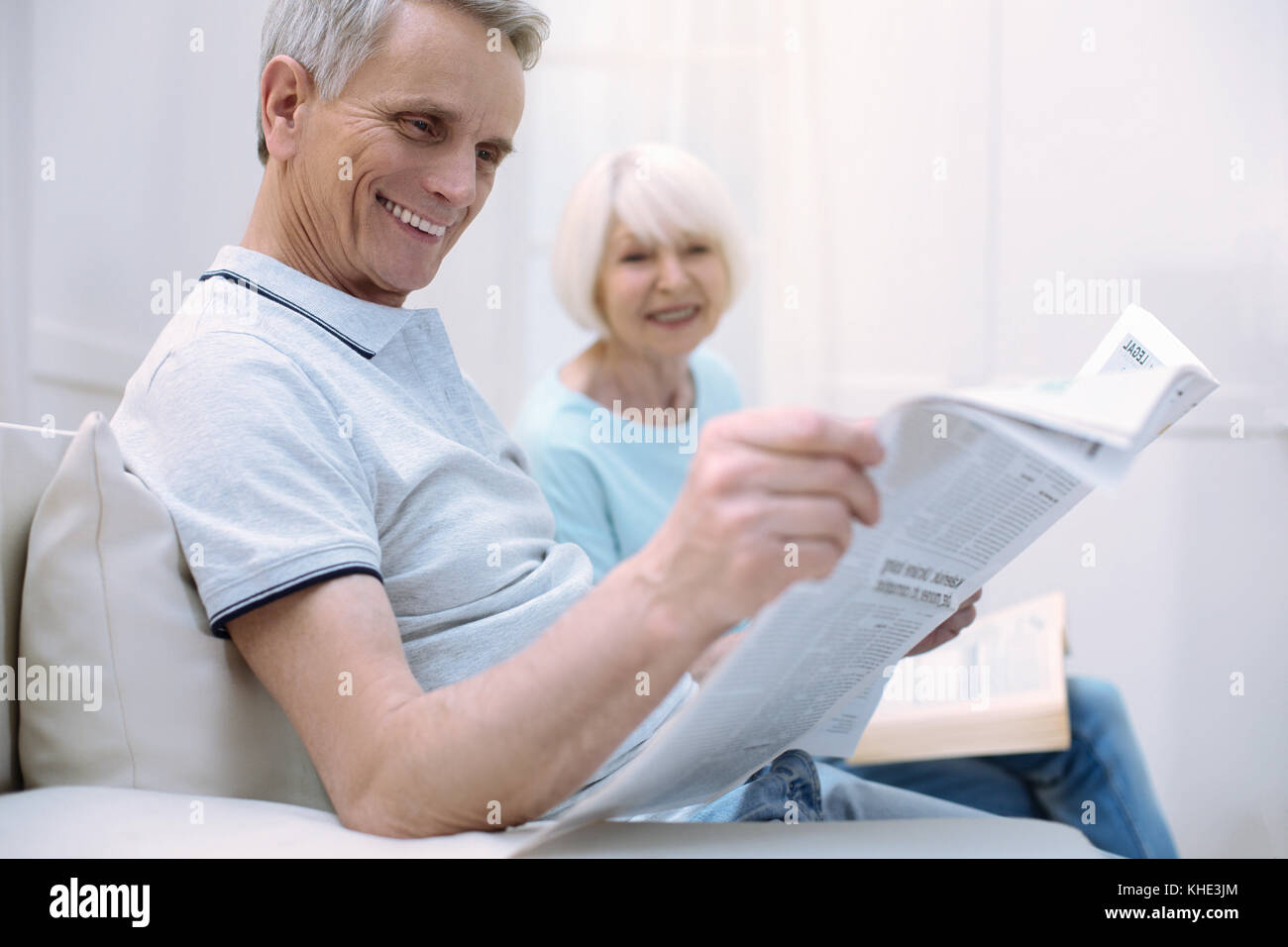 Senior man laughing while reading a newspaper Stock Photo - Alamy