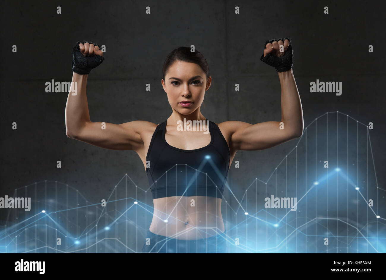 young woman flexing muscles in gym Stock Photo - Alamy