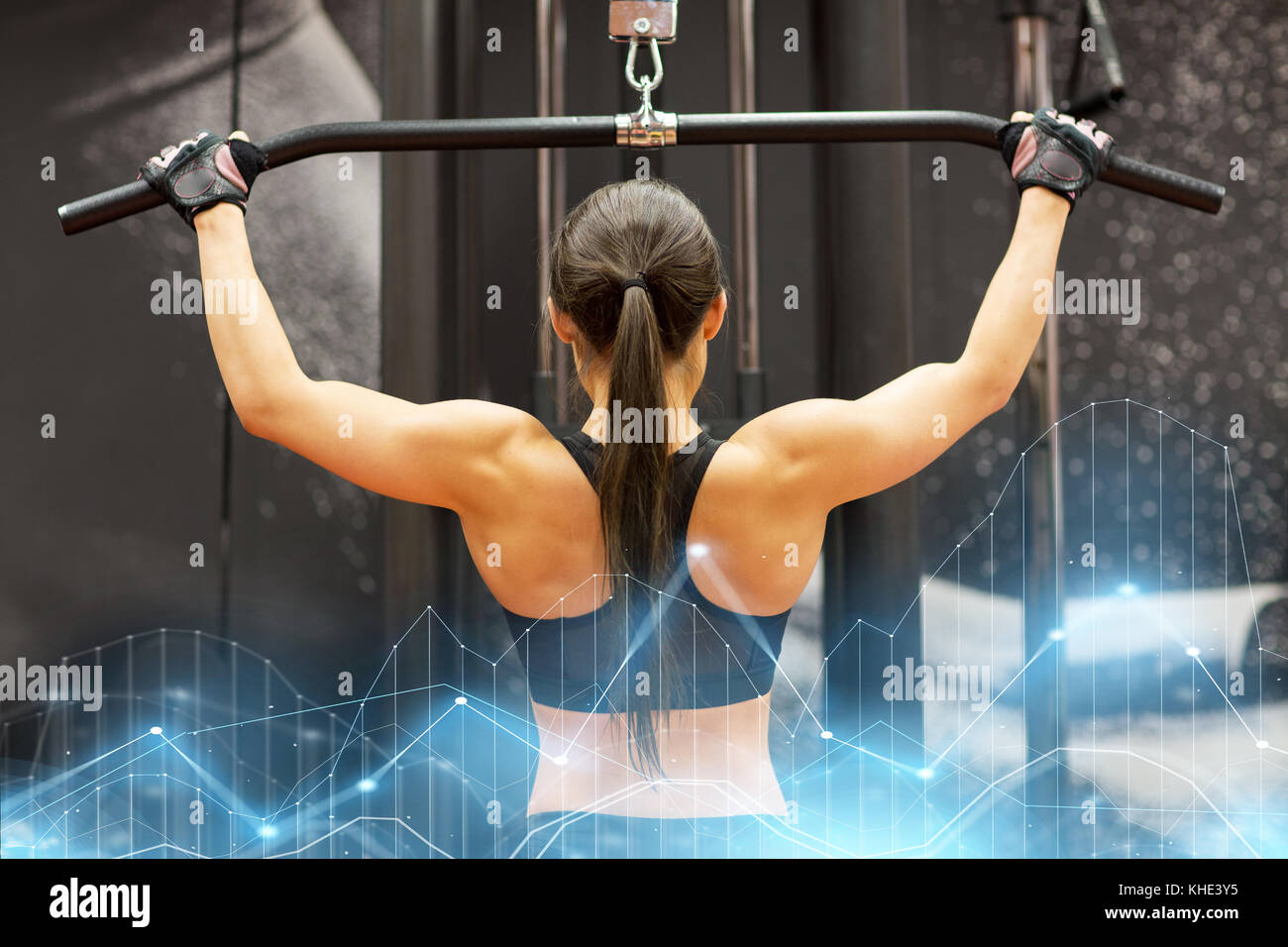 woman flexing muscles on cable machine in gym Stock Photo - Alamy