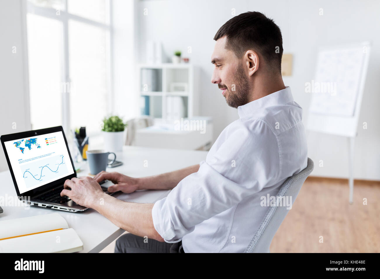 businessman with charts on laptop screen at office Stock Photo - Alamy