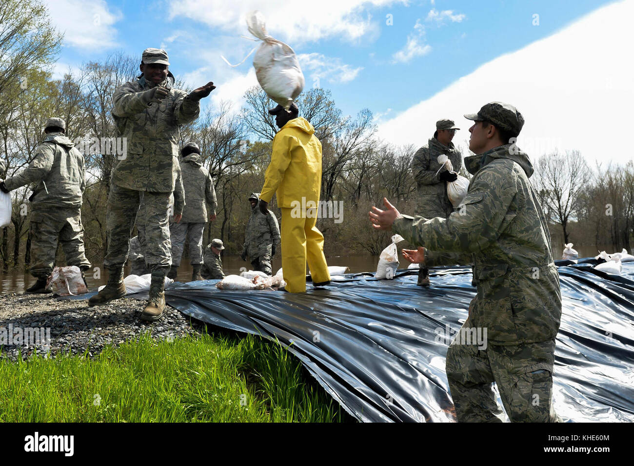 An airman throws a sandbag to his partner during the construction of ...