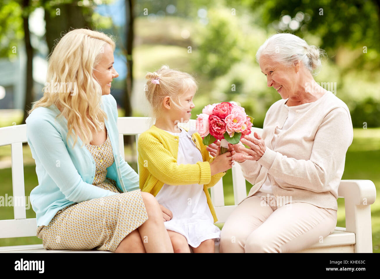happy family giving flowers to grandmother at park Stock Photo - Alamy