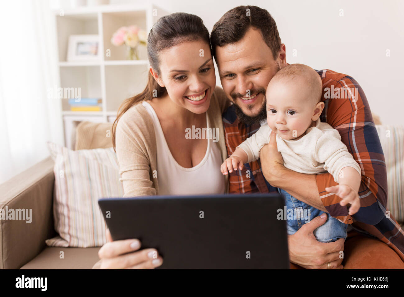 mother, father and baby with tablet pc at home Stock Photo - Alamy