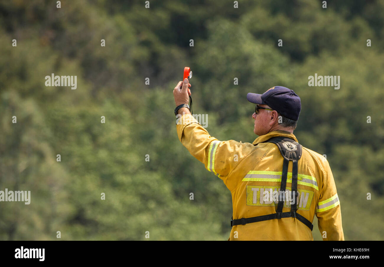 A wildland firefighter measures wind speed in the U.S. Department of ...