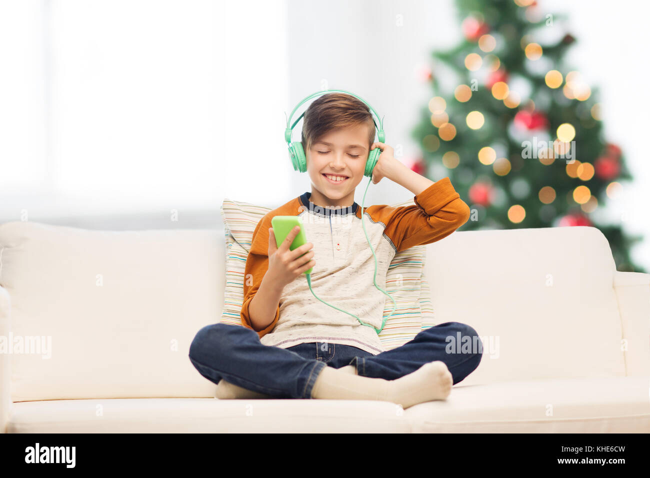 boy with smartphone and headphones at christmas Stock Photo - Alamy