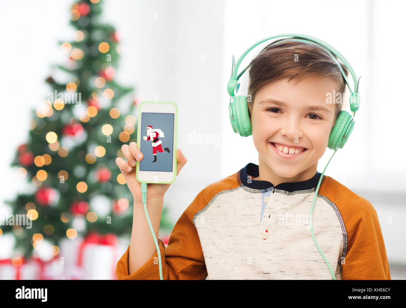 boy with smartphone and headphones at christmas Stock Photo - Alamy