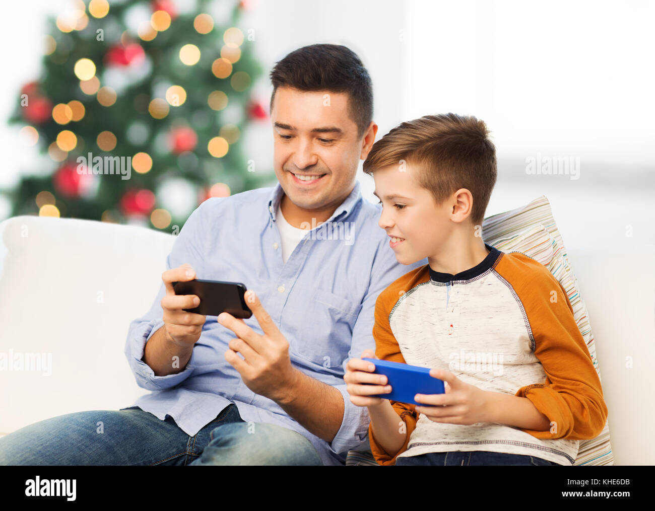 happy father and son with smartphones at christmas Stock Photo - Alamy