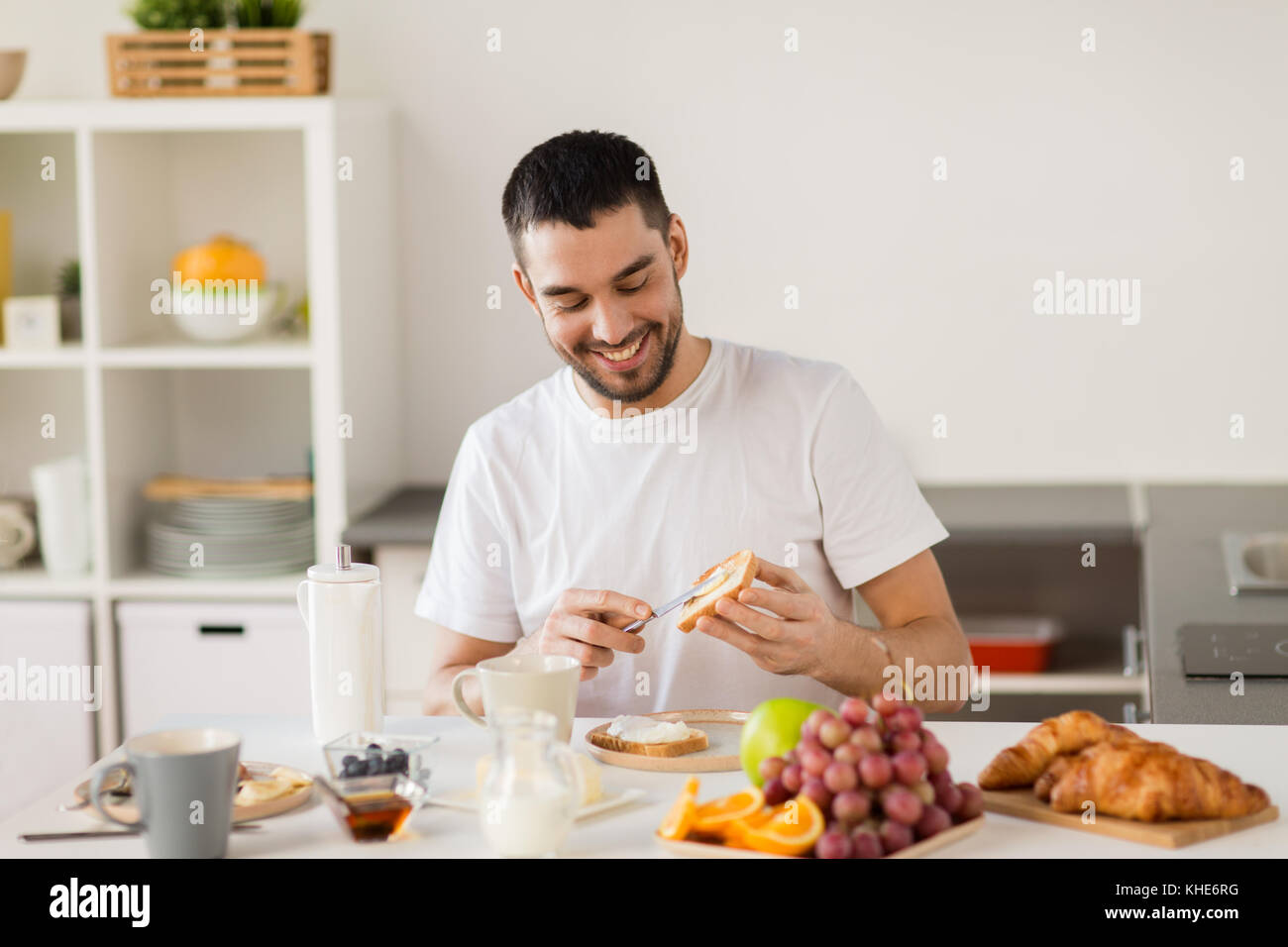 man eating toast with coffee at home kitchen Stock Photo - Alamy