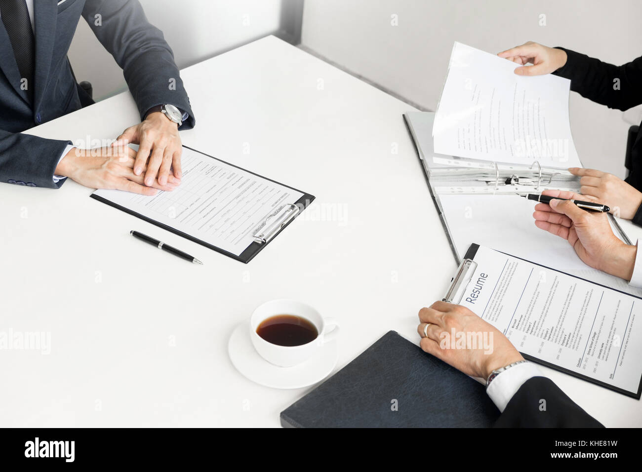 Panel of business people conducting job interview with male candidate ...