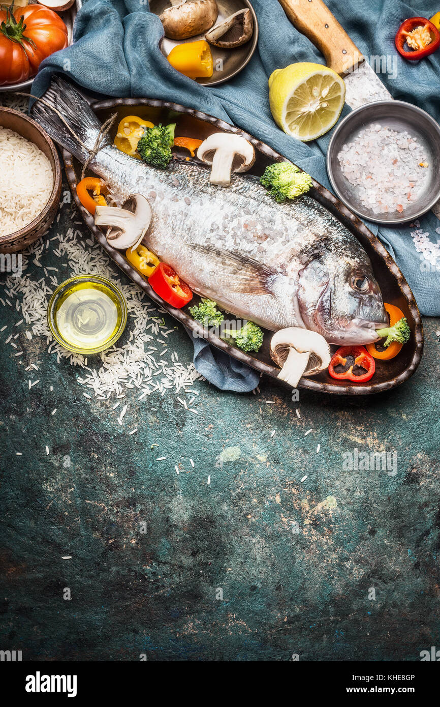 Fish and vegetables cooking with ingredients, dorado in baking form ...