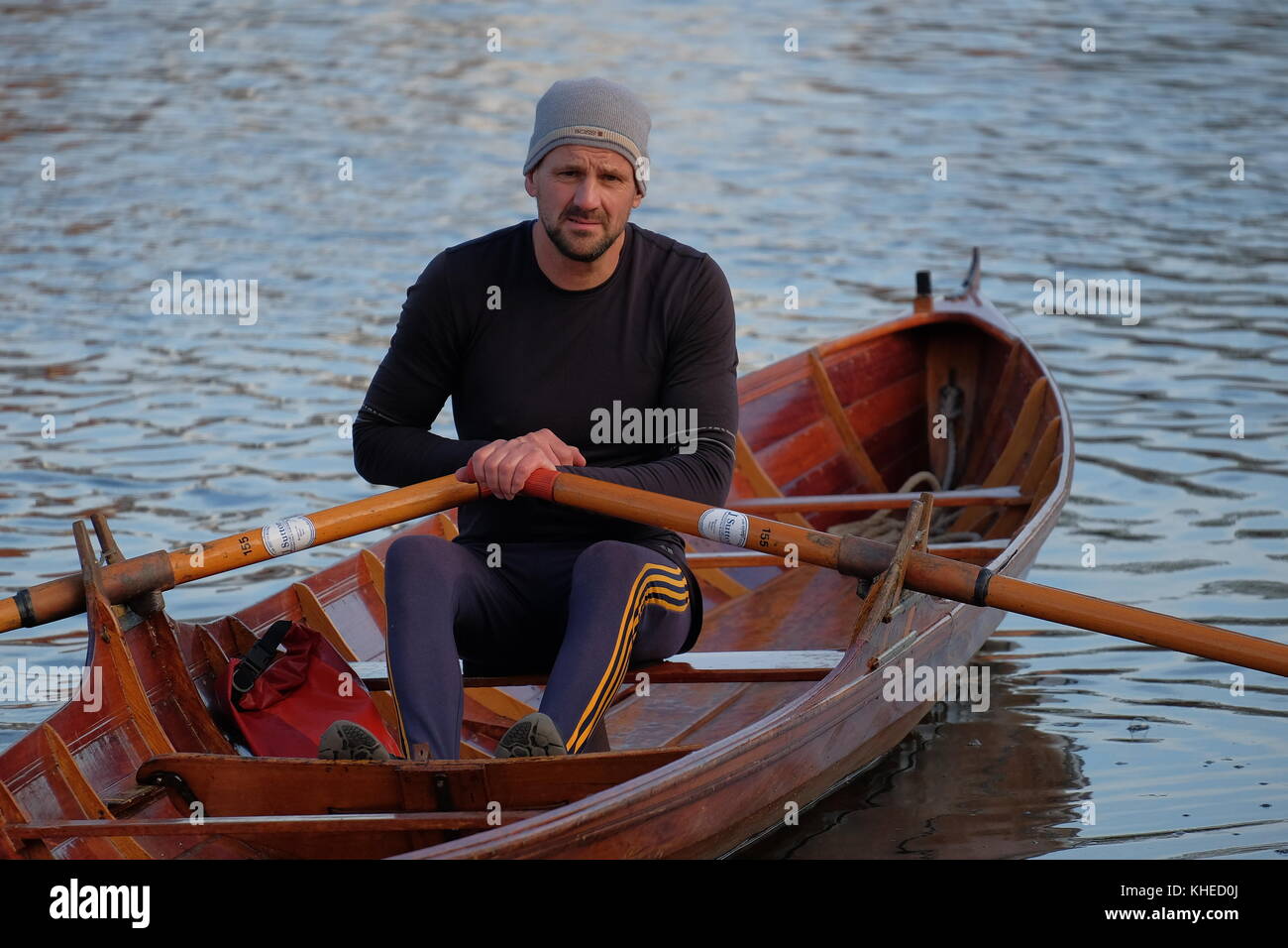 man rowing wooden skiff boat on river thames Stock Photo - Alamy