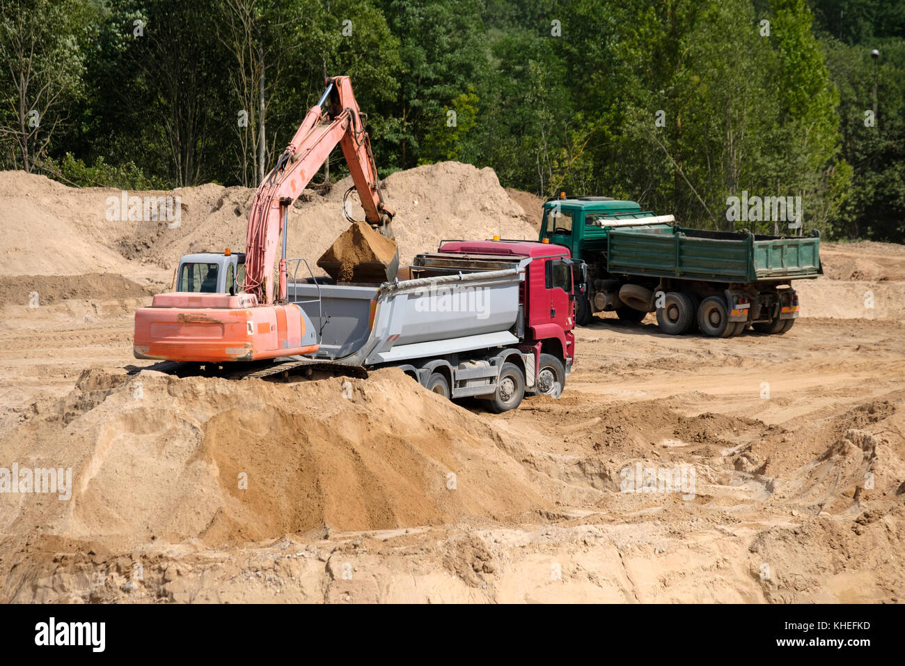 Excavator loading dumper truck construction hi-res stock photography ...