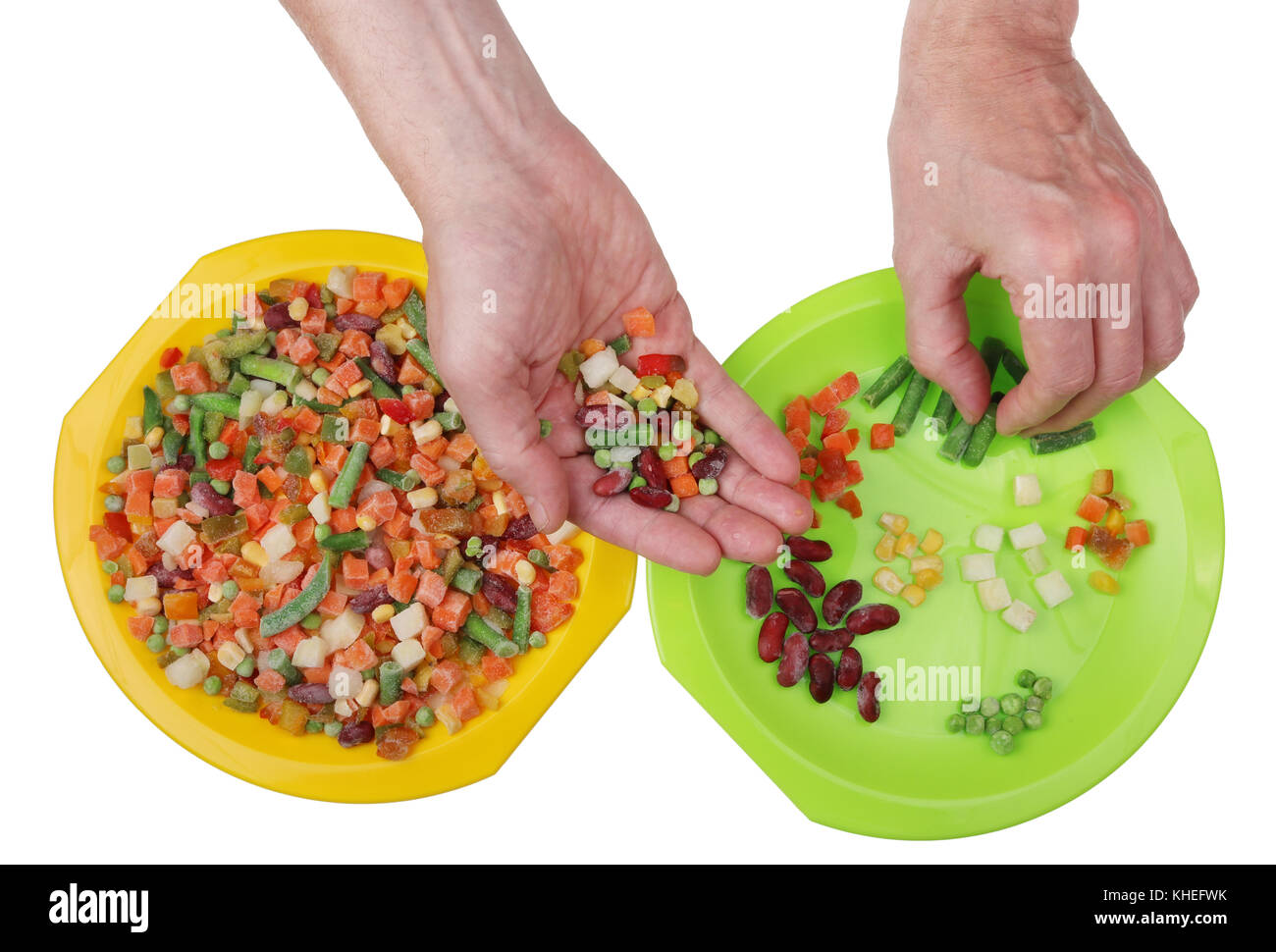 Frozen "Mexican" vegetable mix sorting with hands. On one plate - the ...
