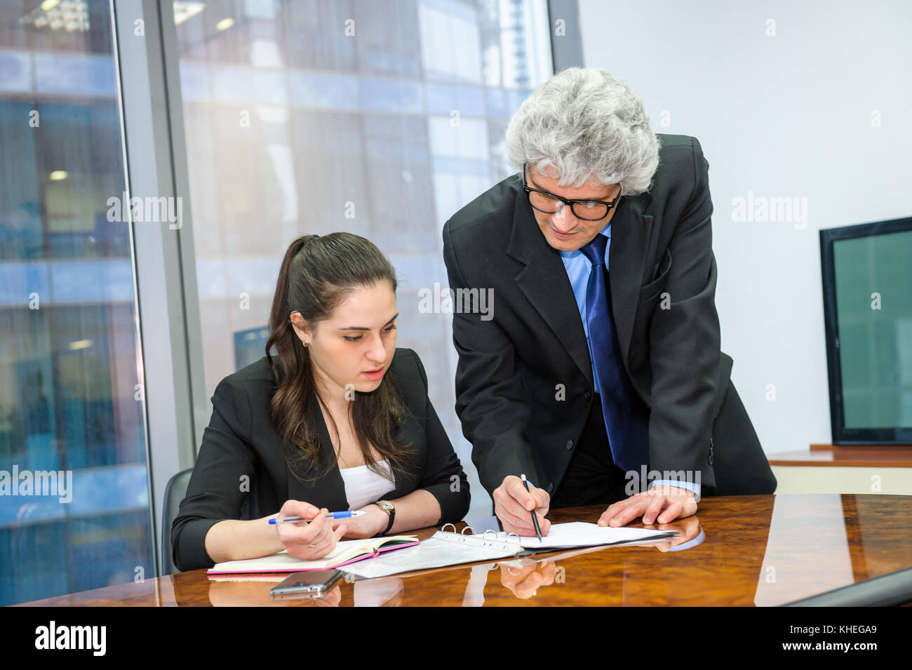 Mature businessman helping a young employee Stock Photo - Alamy