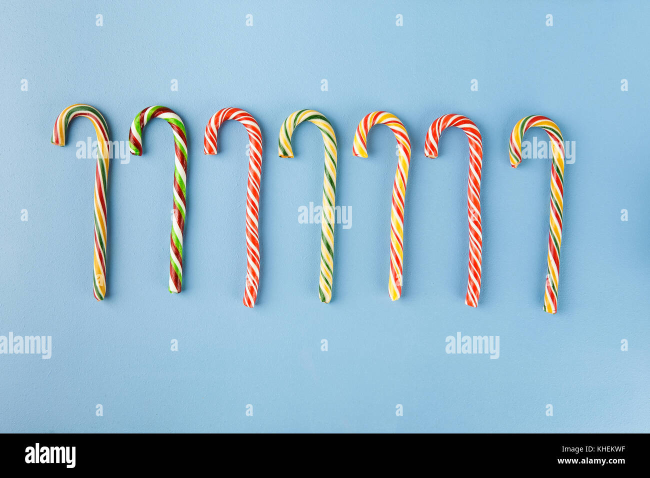 Sweet Candy canes on blue background. Flat lay. Top view Stock Photo ...