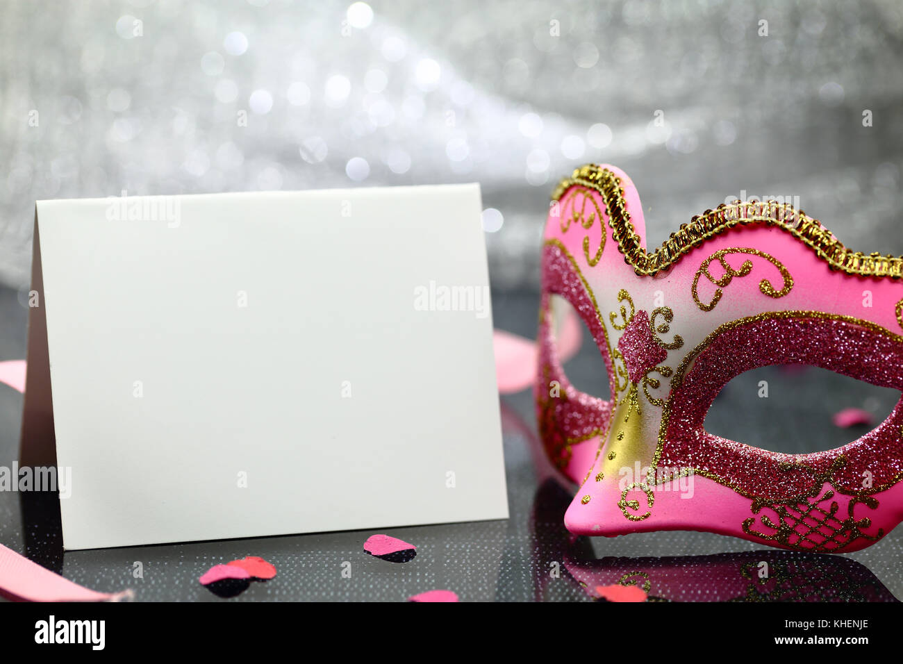 Vintage carnival mask and white blank card in front of glittering ...