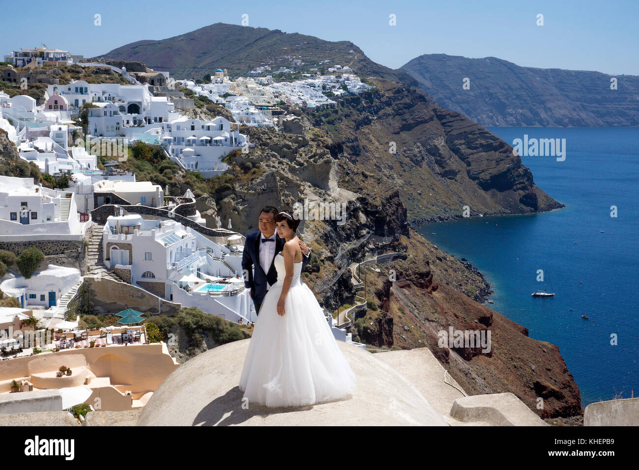 Bridal couple at the crater edge, viewpoint at the village Oia ...