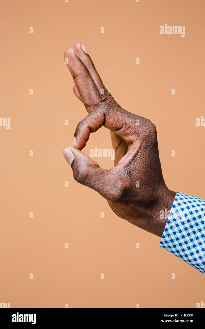 Hand showing OK sign isolated on brown background Stock Photo - Alamy