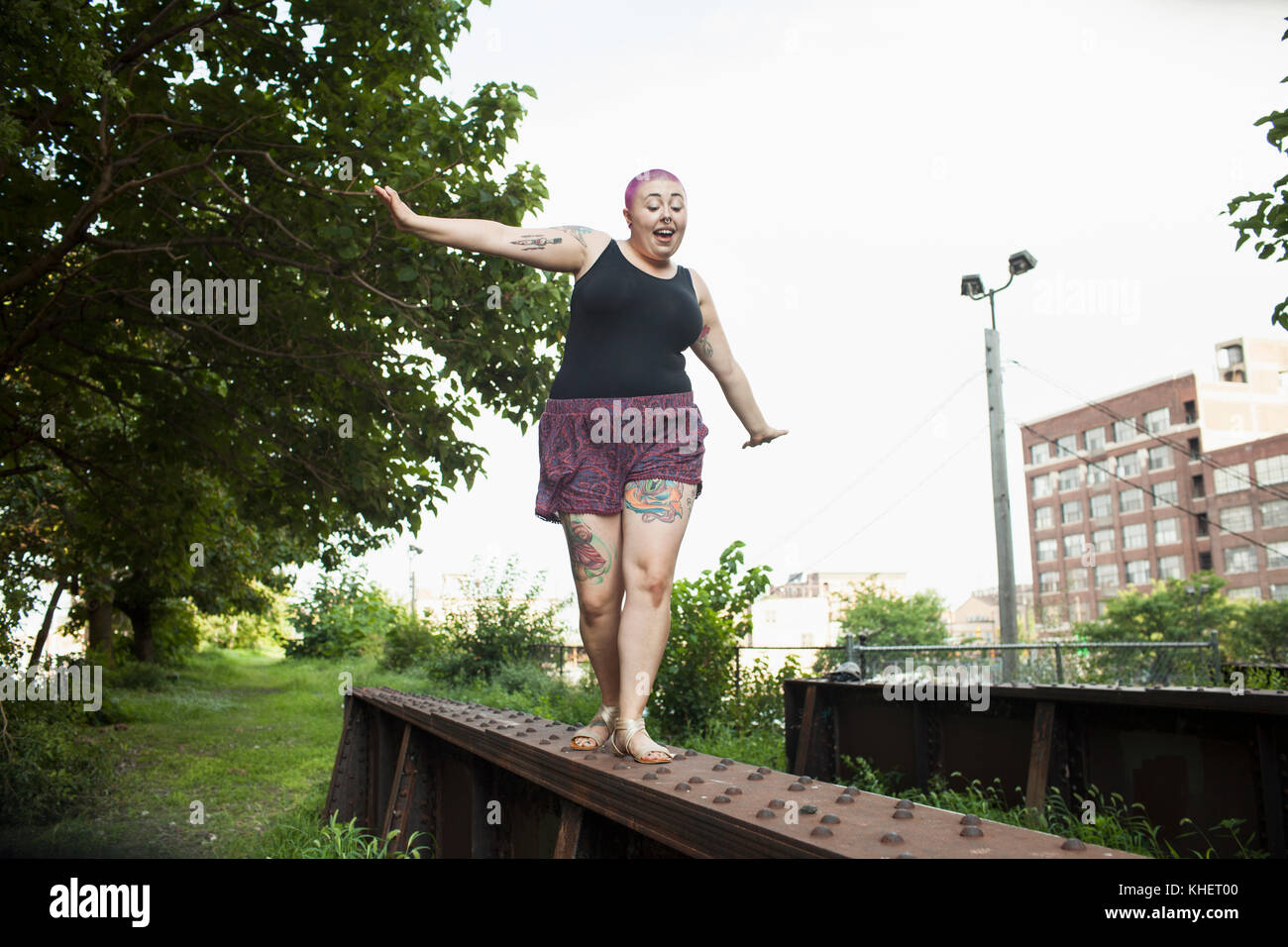 A young woman balancing on a bench Stock Photo - Alamy