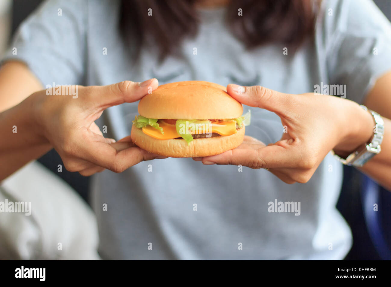 Close-up fast food burger, burger in the young woman hand, holding in ...