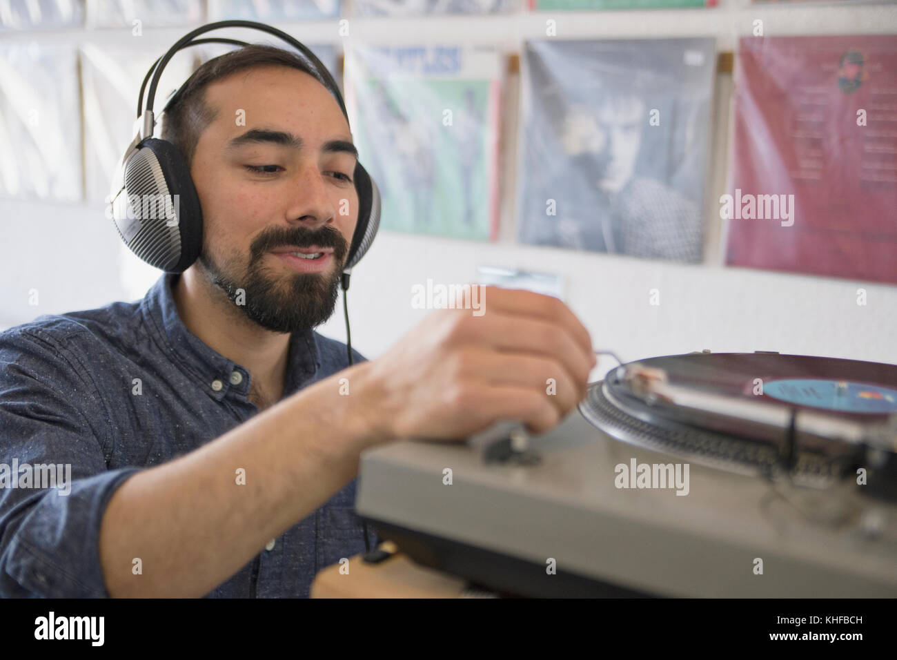 Young man listening to a record at a record store Stock Photo - Alamy