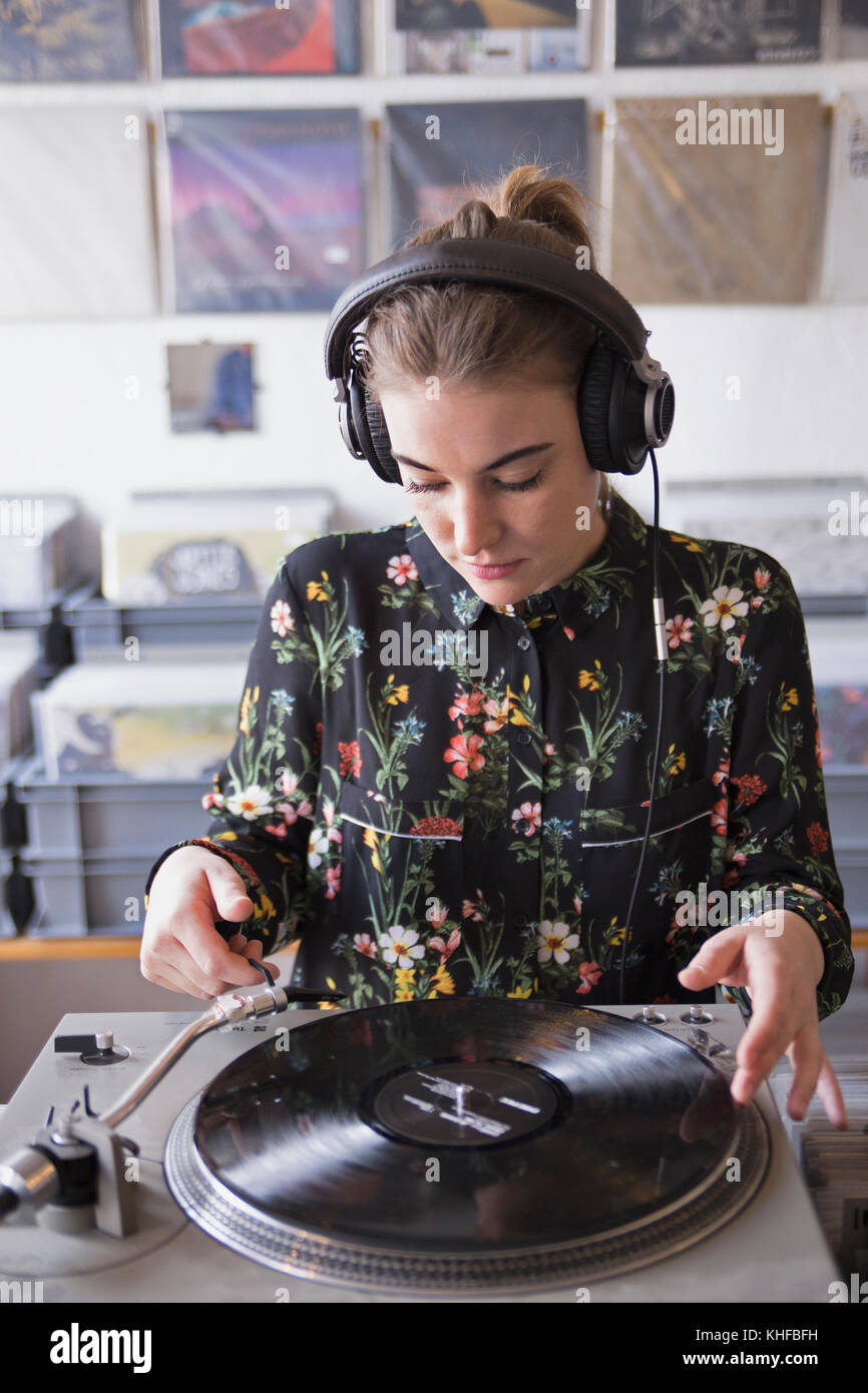 Young woman listening to record in a record store Stock Photo - Alamy