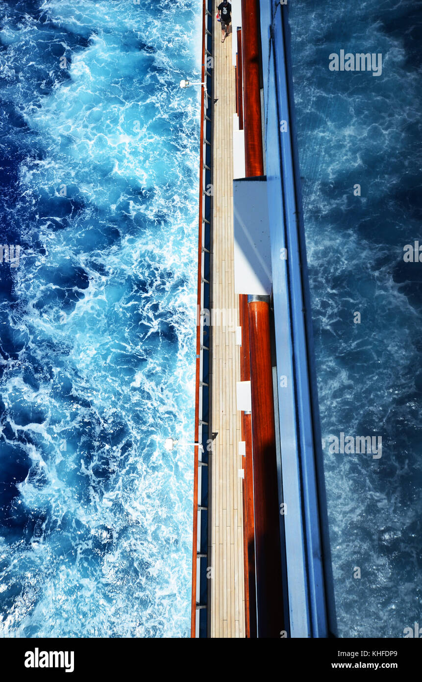 view down to deck on cruise ship with reflection of ocean in window ...