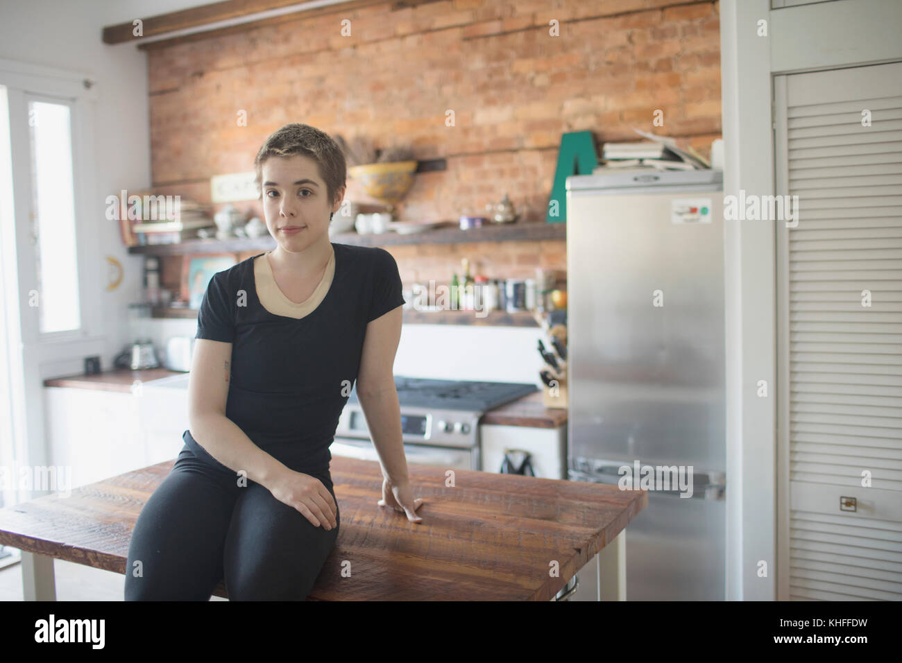 Transgender person sitting on their kitchen counter Stock Photo - Alamy