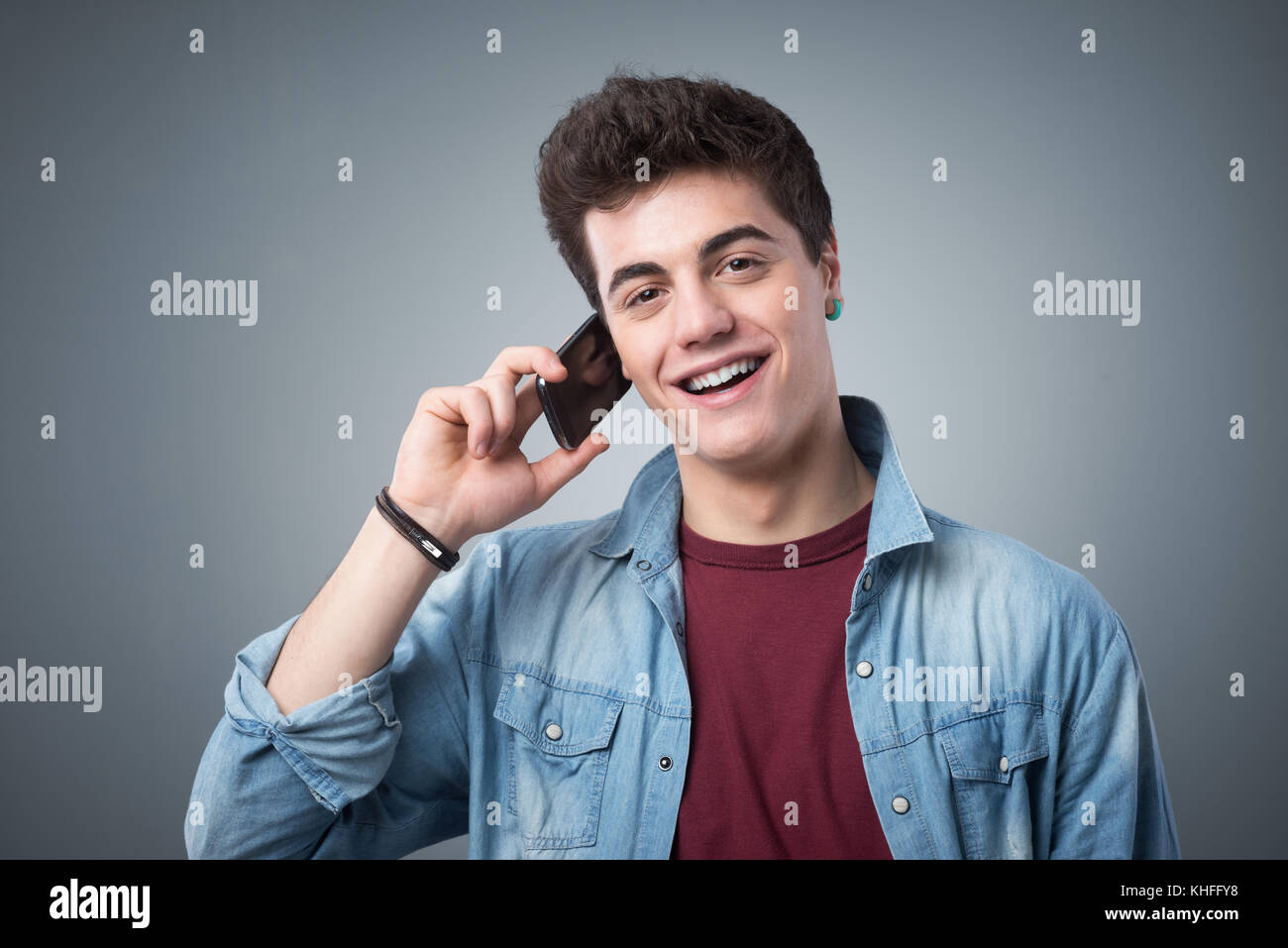 Smiling carefree teenager boy having a phone call with mobile Stock ...