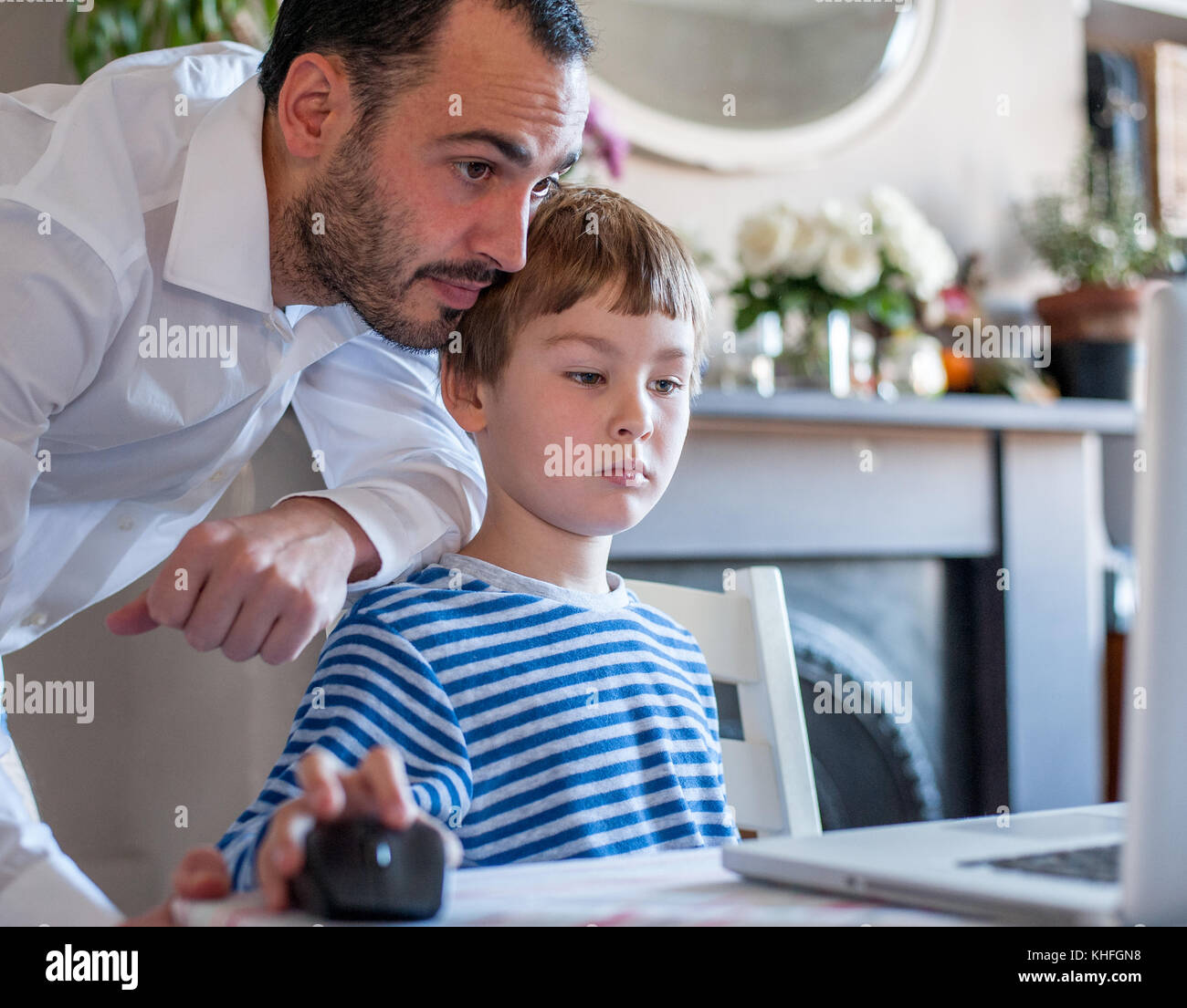 Father and son focusing on laptop screen Stock Photo - Alamy