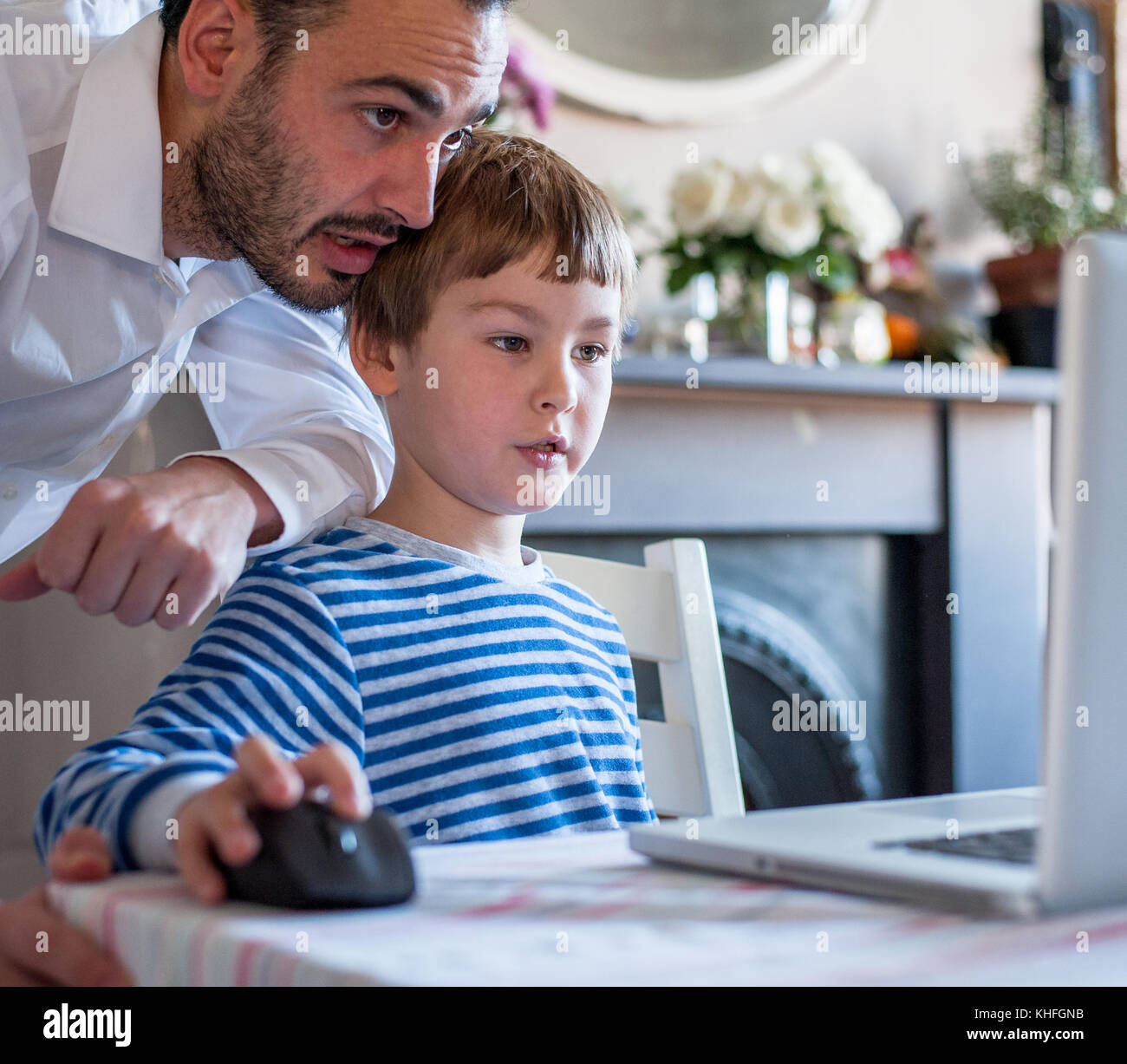 Father and son focusing on laptop screen Stock Photo - Alamy