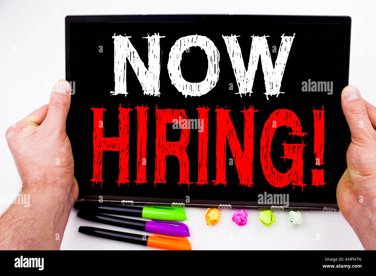 Now Hiring text written on tablet, computer in the office with marker ...