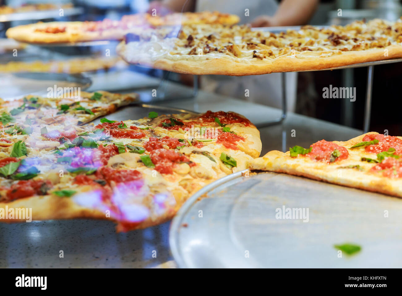 Handsome pizzaiolo making pizza at kitchen in pizzeria. Fresh Italian ...