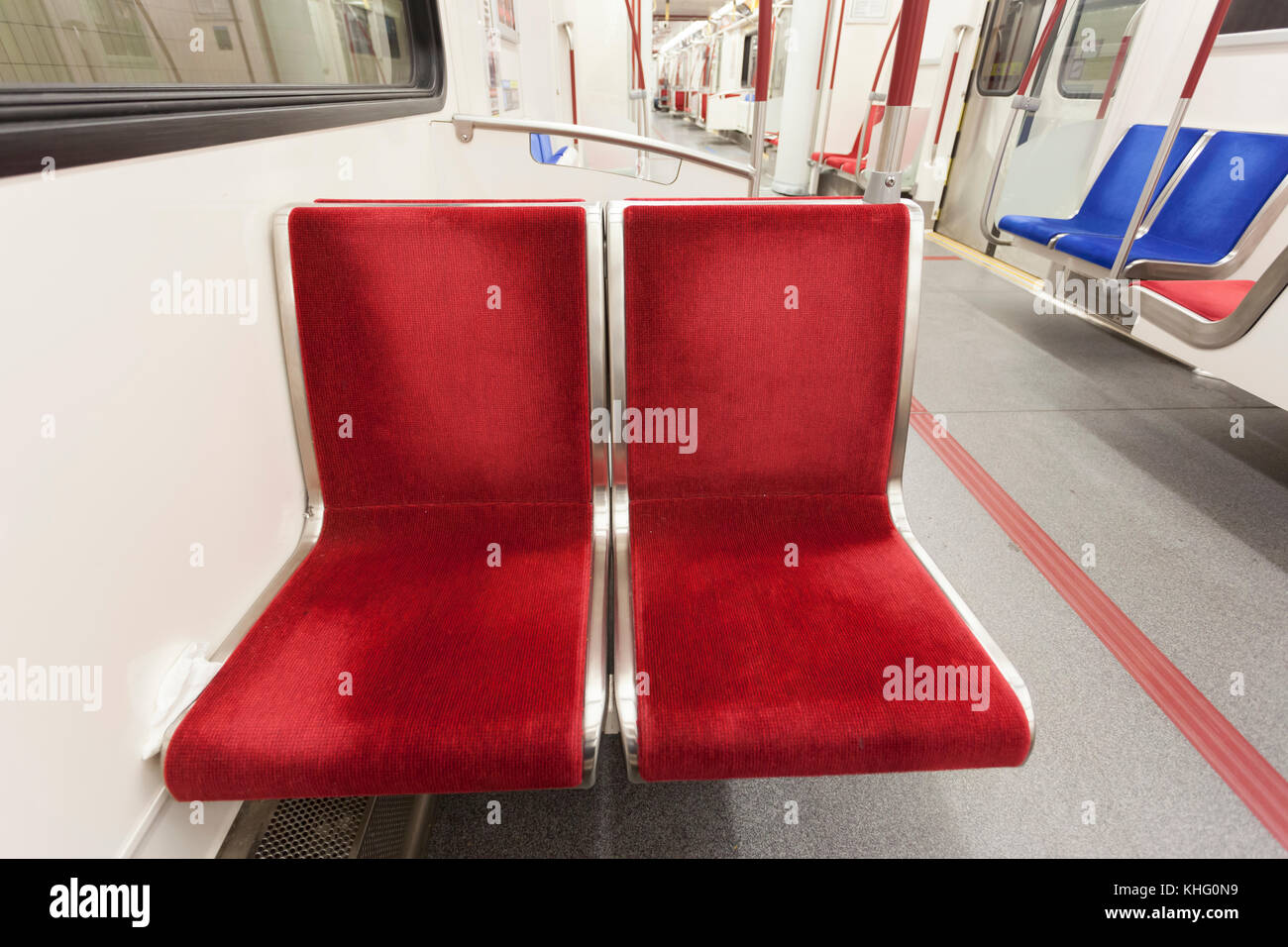 Empty red and blue seats in a subway train Stock Photo - Alamy