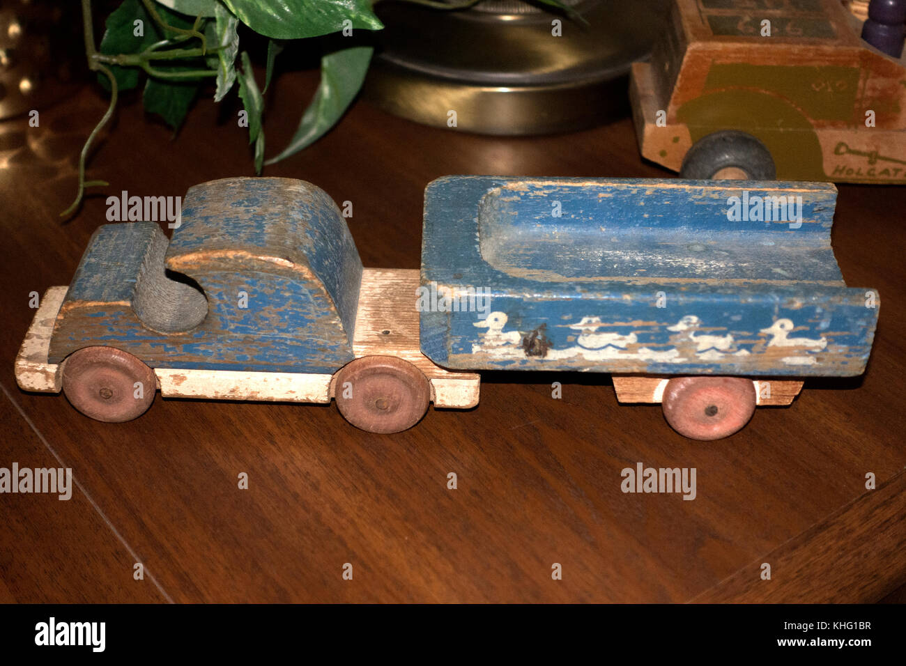 Blue antique wooden car pulling a trailer with floating ducks on the ...