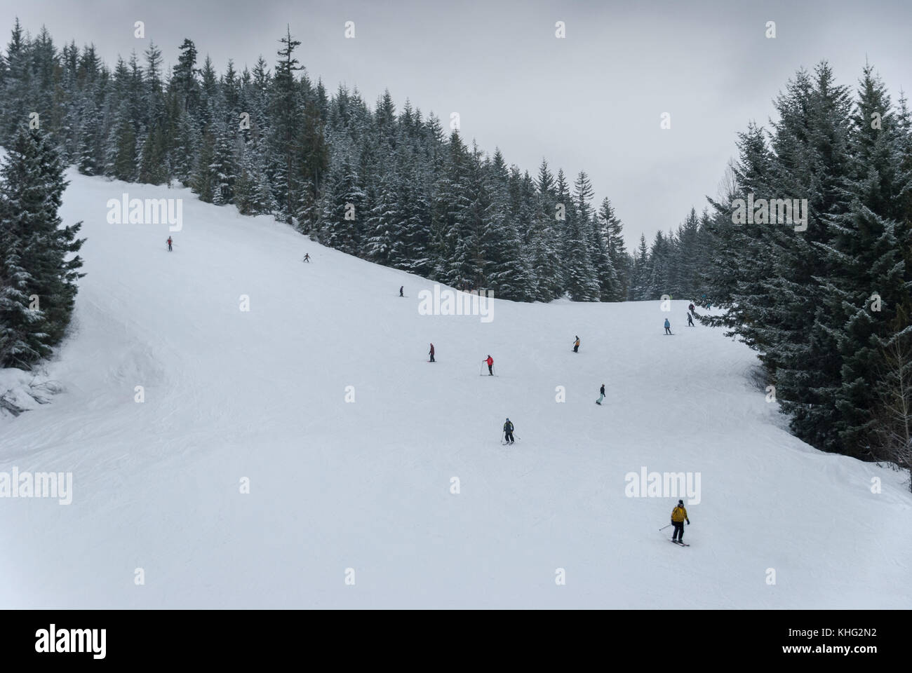 Aerial photo of large group of people skiing and snowboarding from top ...
