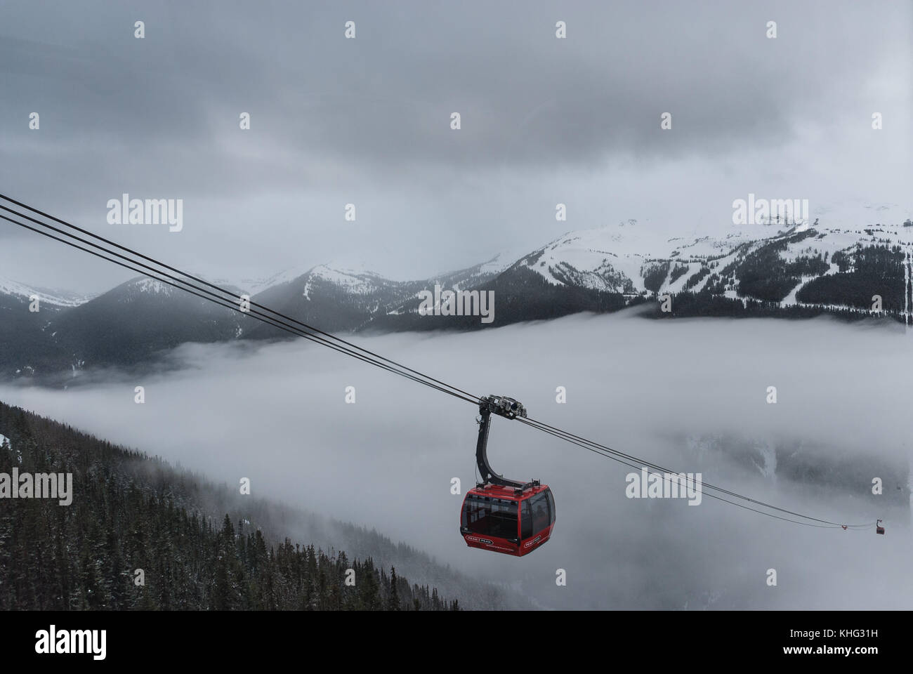 Cable car running between two snow covered mountains at a ski resort ...